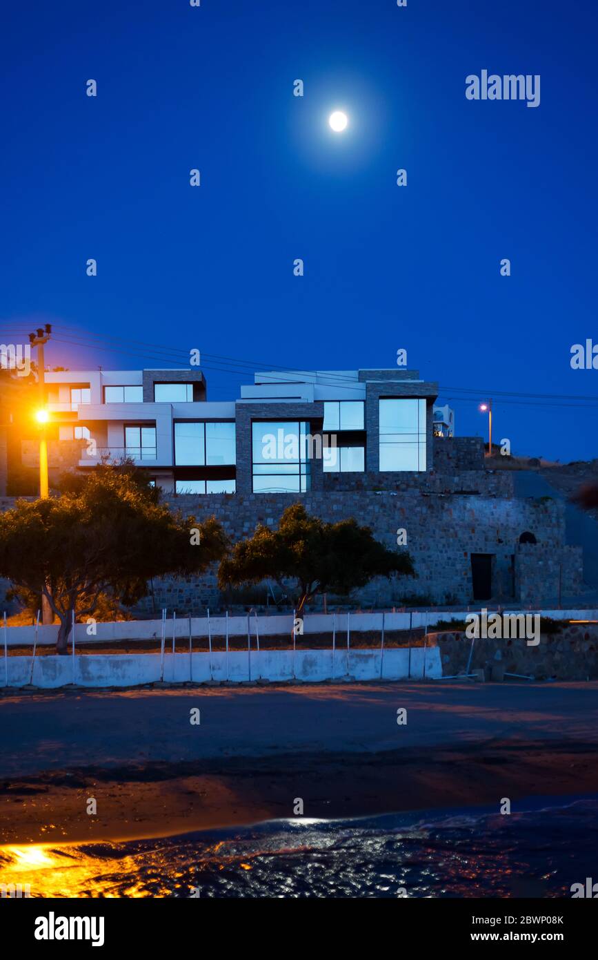 Nice modern house near sea with light moon Stock Photo - Alamy