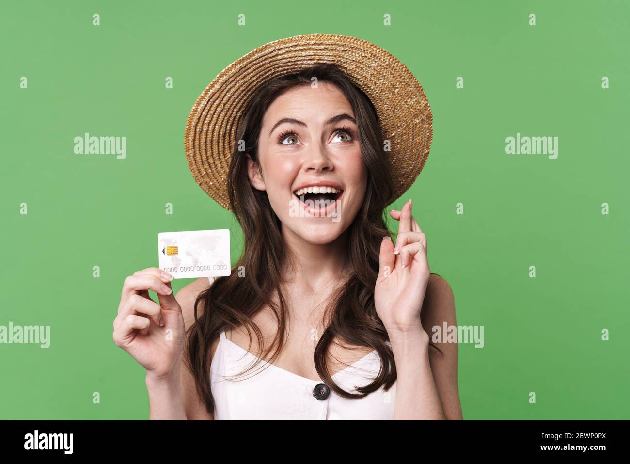 Image of excited woman in straw hat holding credit card and fingers ...