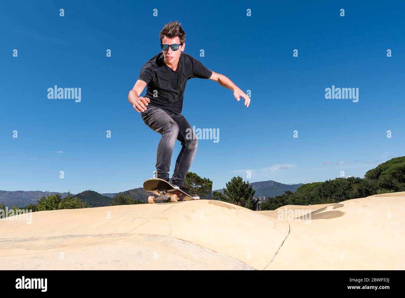 Skateboarder practice on a pump track park on a sunny summer day Stock ...