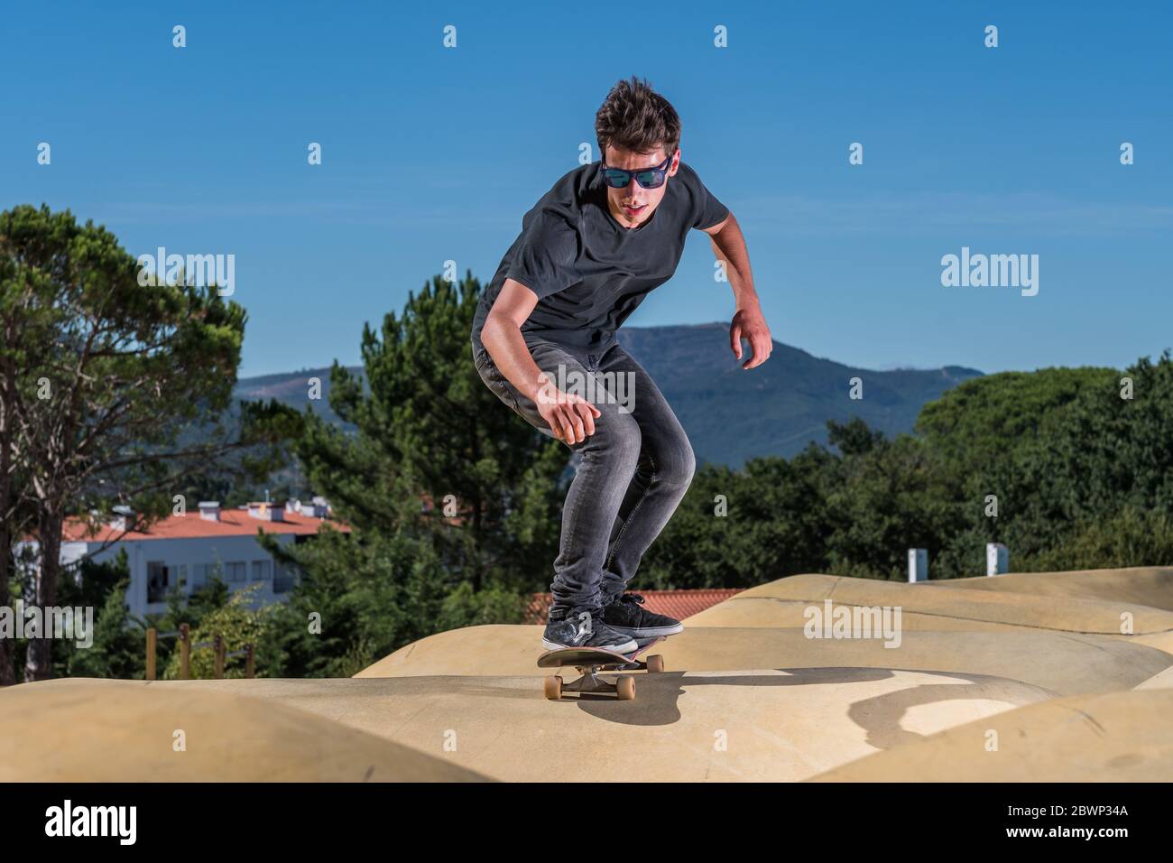 Skateboarder practice on a pump track park on a sunny summer day Stock ...