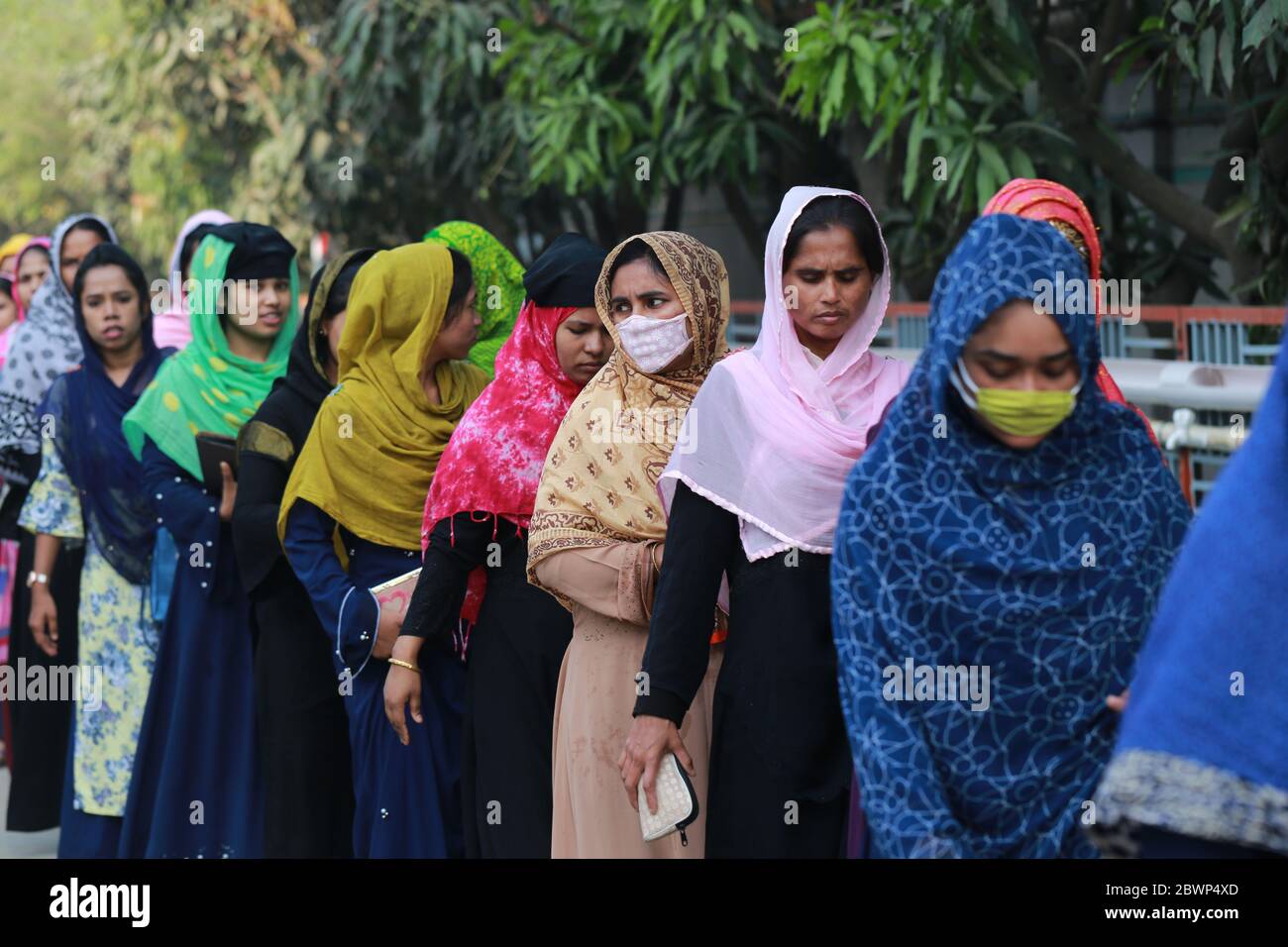 Female workers walk in a queue to join their works inside a garment ...