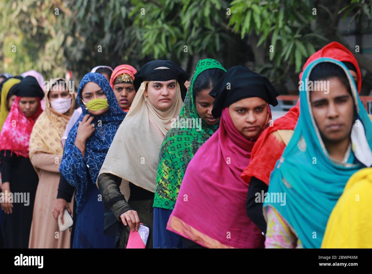 Female workers walk in a queue to join their works inside a garment ...