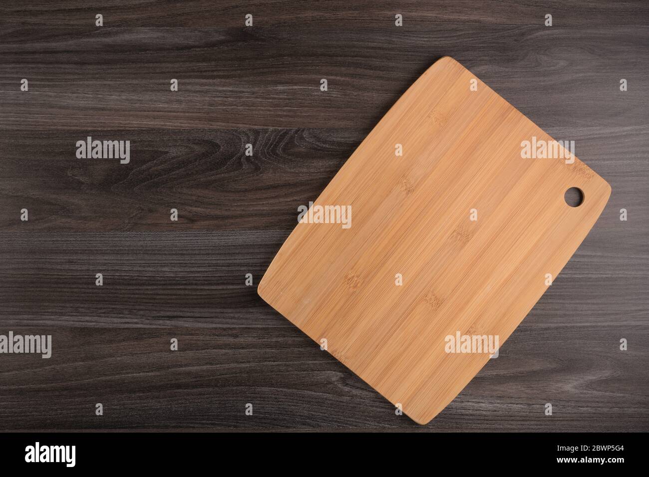 Top view of wooden cutting board on old dark wood countertop Stock ...