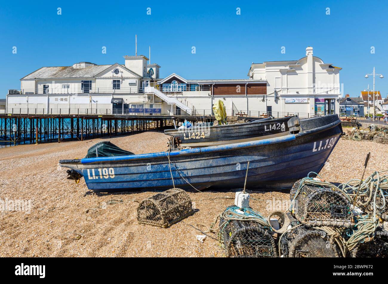 Small fishing boats beached on the shingle beach and lobster pots by ...
