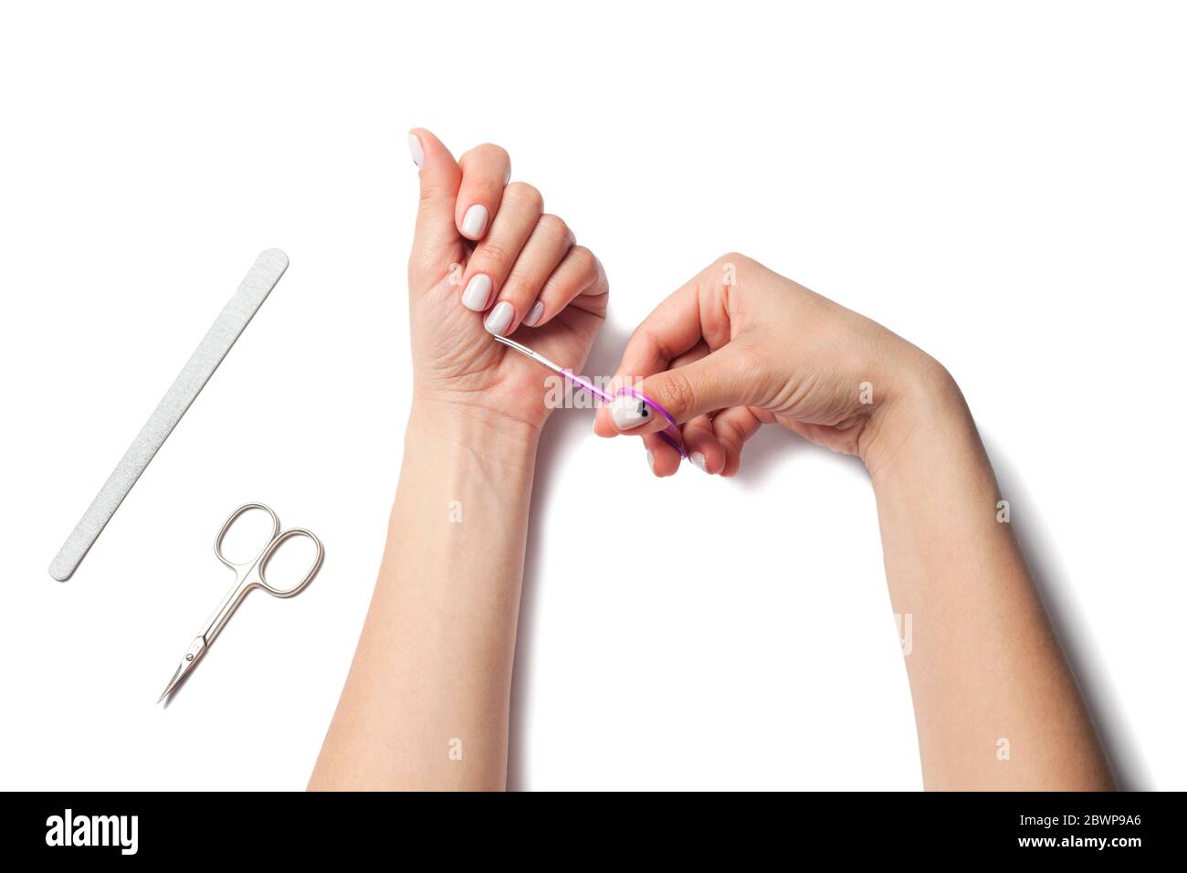 Female hands hold nail scissors, next to lay down devices for nail care ...
