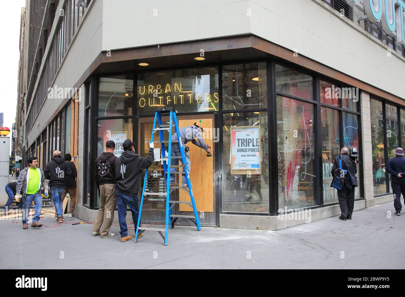 Workers repair and board up shop windows at Urban Outfitters in Herald ...