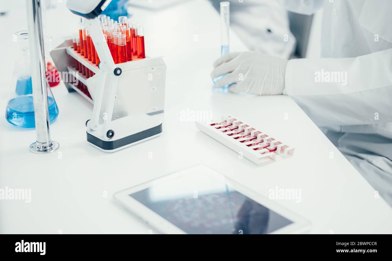 digital tablet and ampoules with the vaccine on the table in the ...