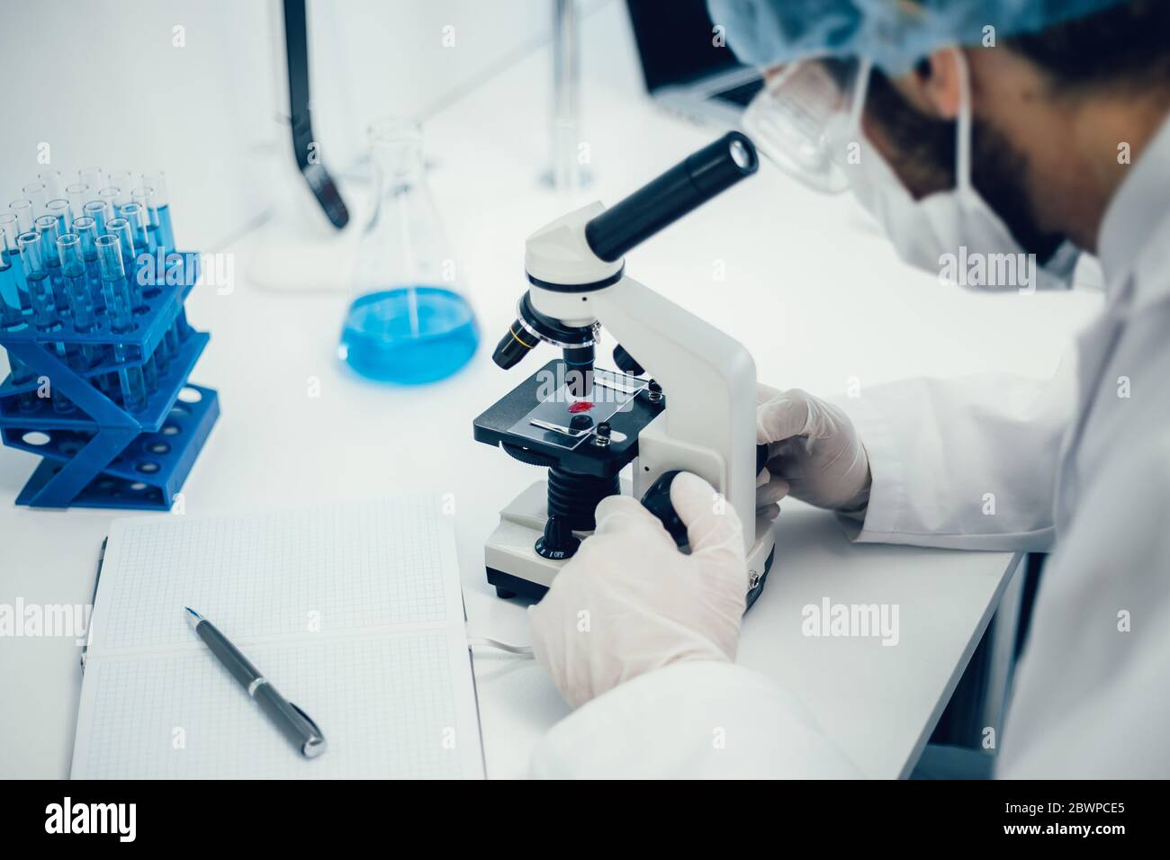 close up. scientist looking at control samples through a microscope ...