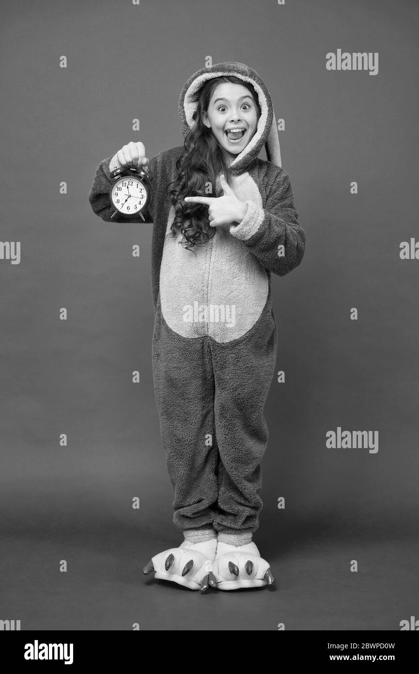 Counting time. It is weekend. Adorable bunny hold alarm clock. Small ...