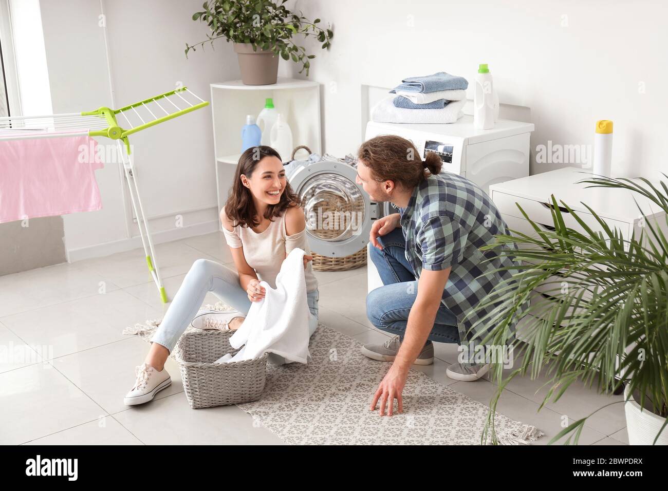 Happy young couple doing laundry at home Stock Photo - Alamy