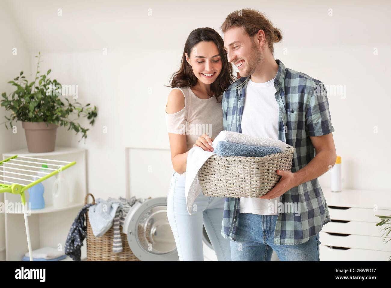 Happy young couple doing laundry at home Stock Photo - Alamy