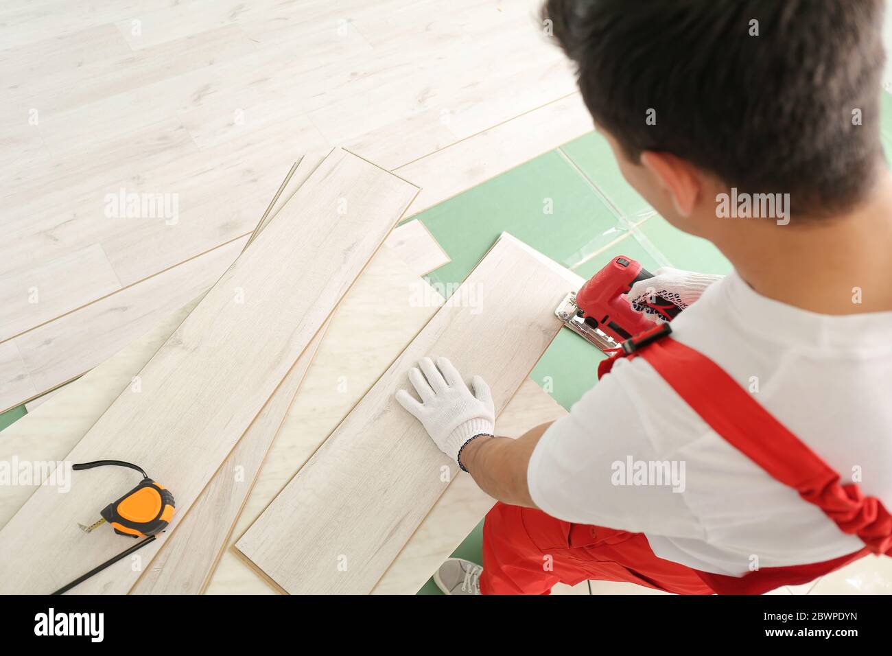 Carpenter installing laminate flooring in room Stock Photo - Alamy
