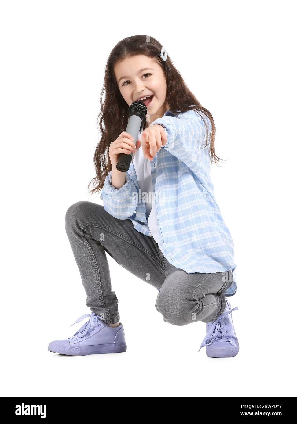 Cute little girl singing against white background Stock Photo - Alamy