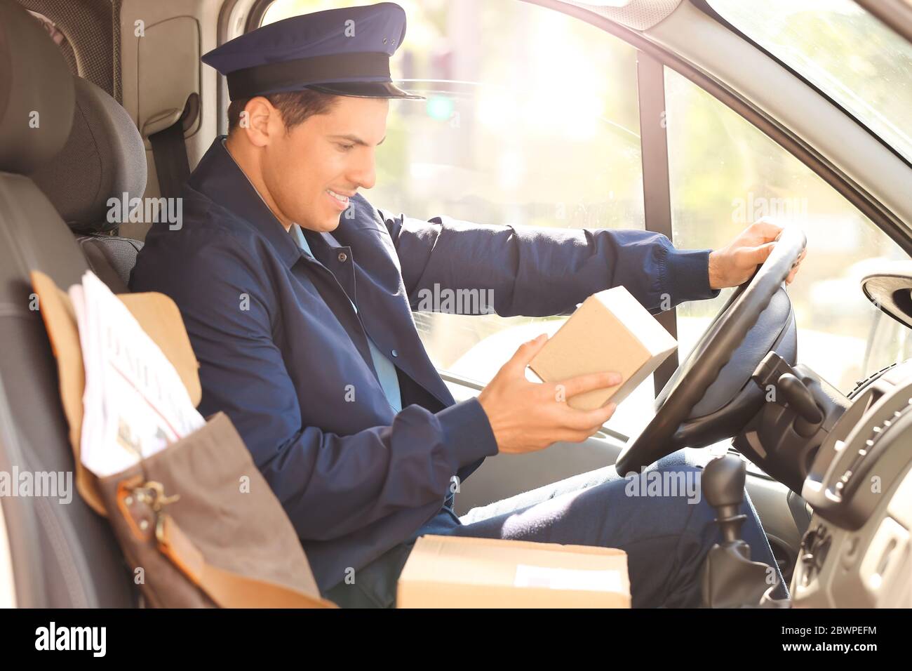 Handsome young postman in car Stock Photo - Alamy