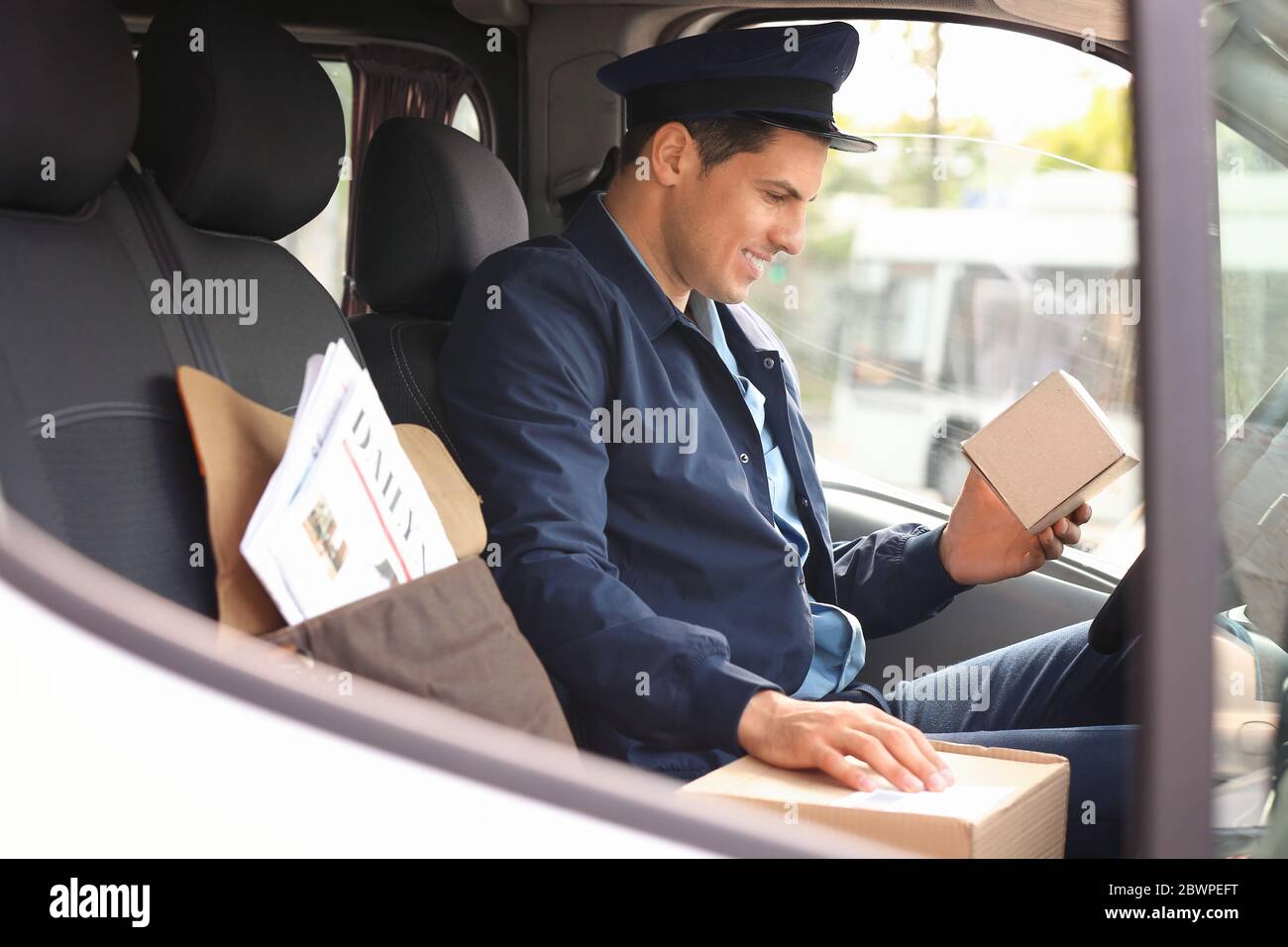 Handsome young postman in car Stock Photo - Alamy