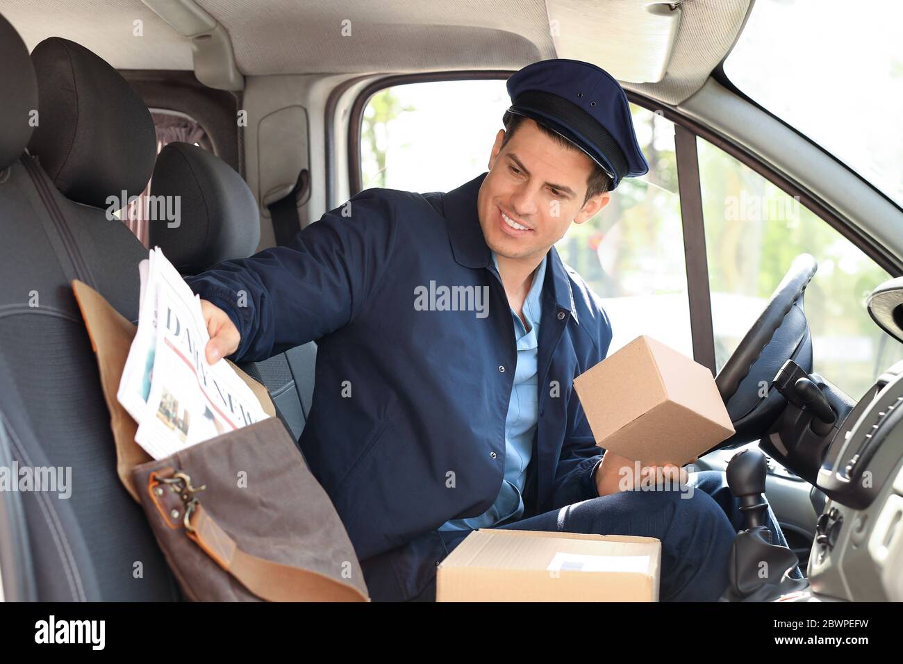 Handsome young postman in car Stock Photo - Alamy