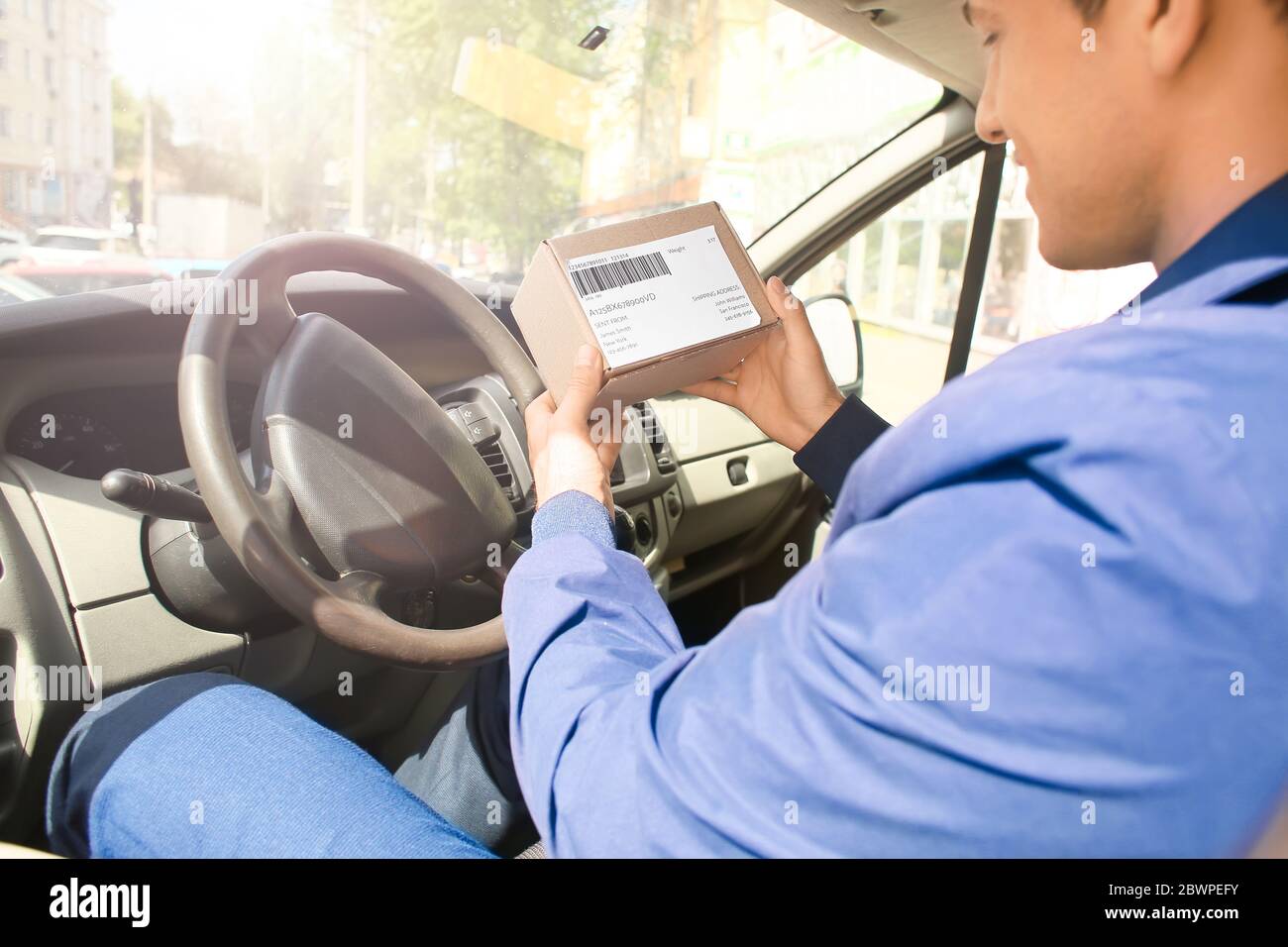 Handsome young postman in car Stock Photo - Alamy