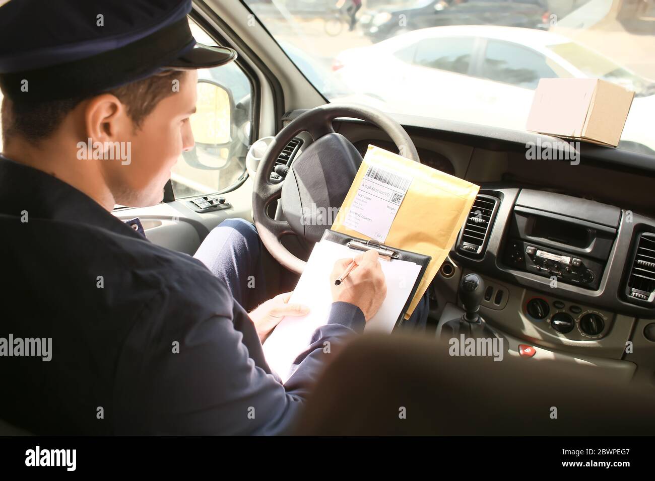 Handsome young postman in car Stock Photo - Alamy