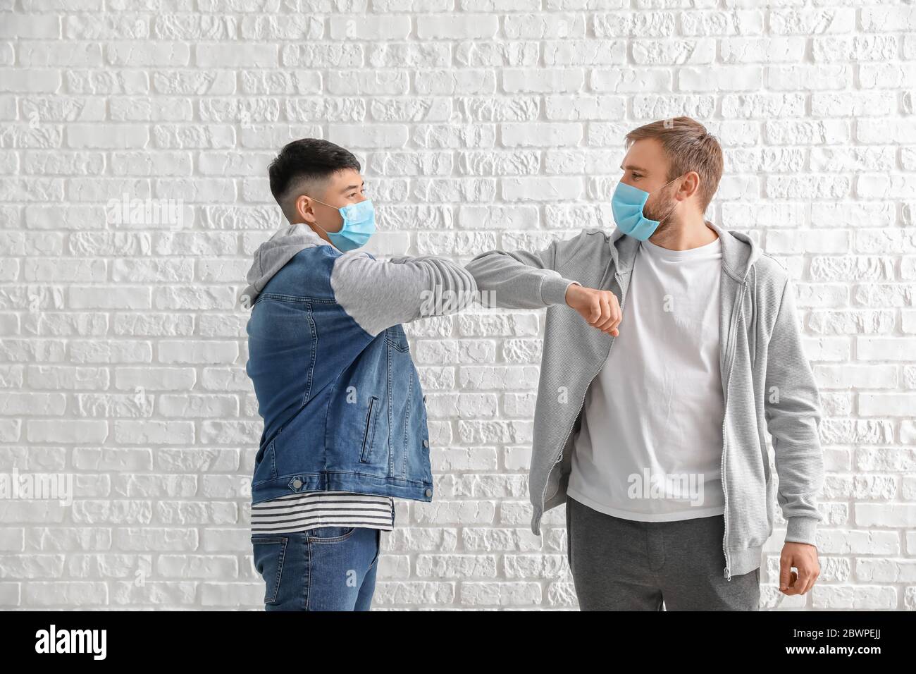 Young men greeting each other on white background. Concept of epidemic ...