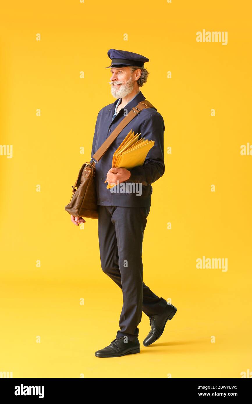 Handsome old postman on color background Stock Photo - Alamy