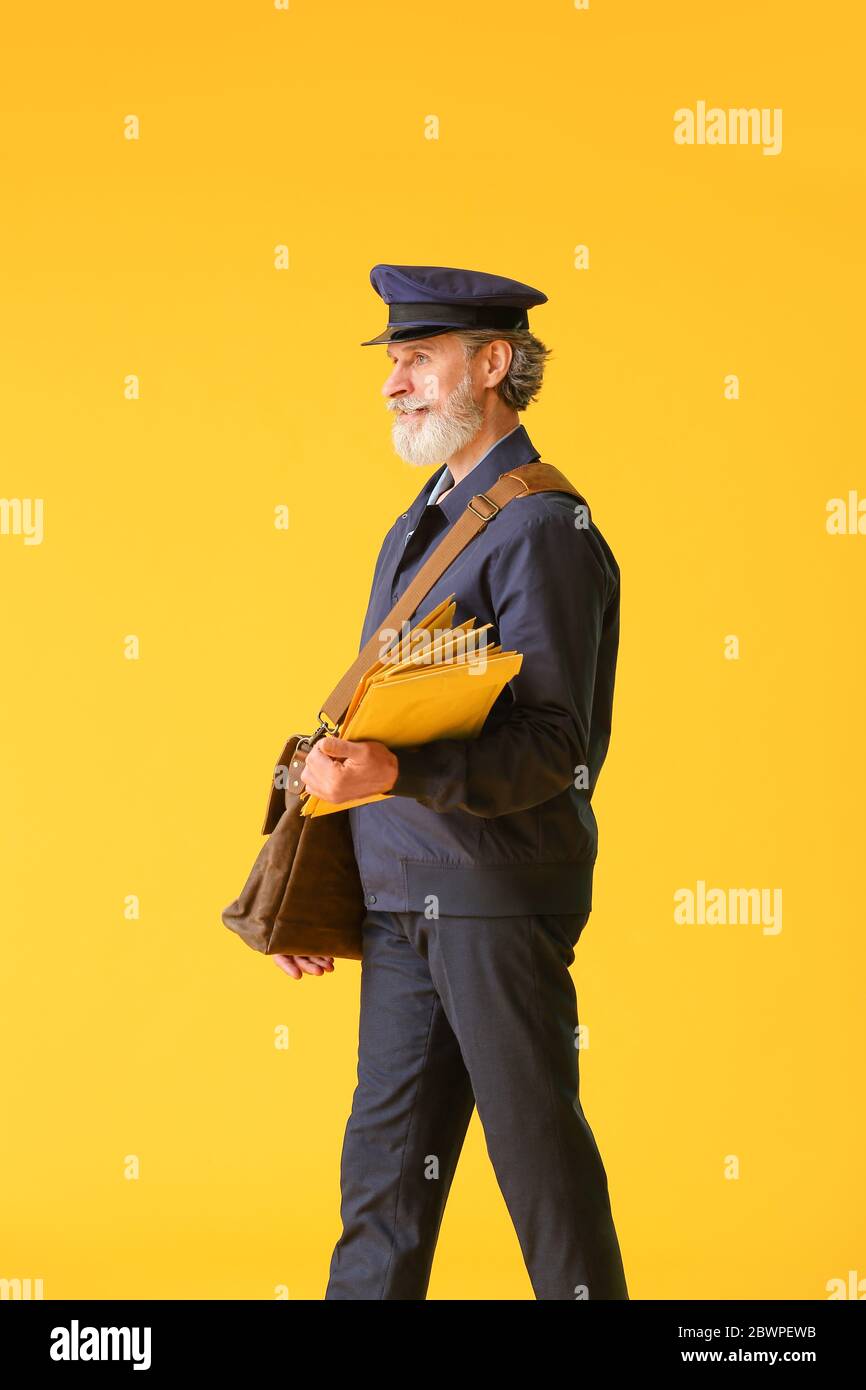 Handsome old postman on color background Stock Photo - Alamy