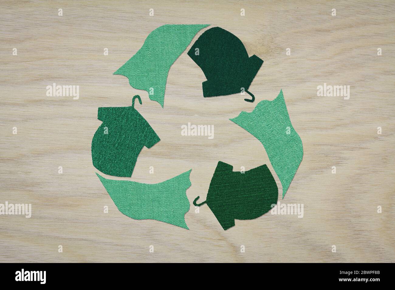 recycle clothes symbol recycle sign cut from reuse textiles on a wooden ...