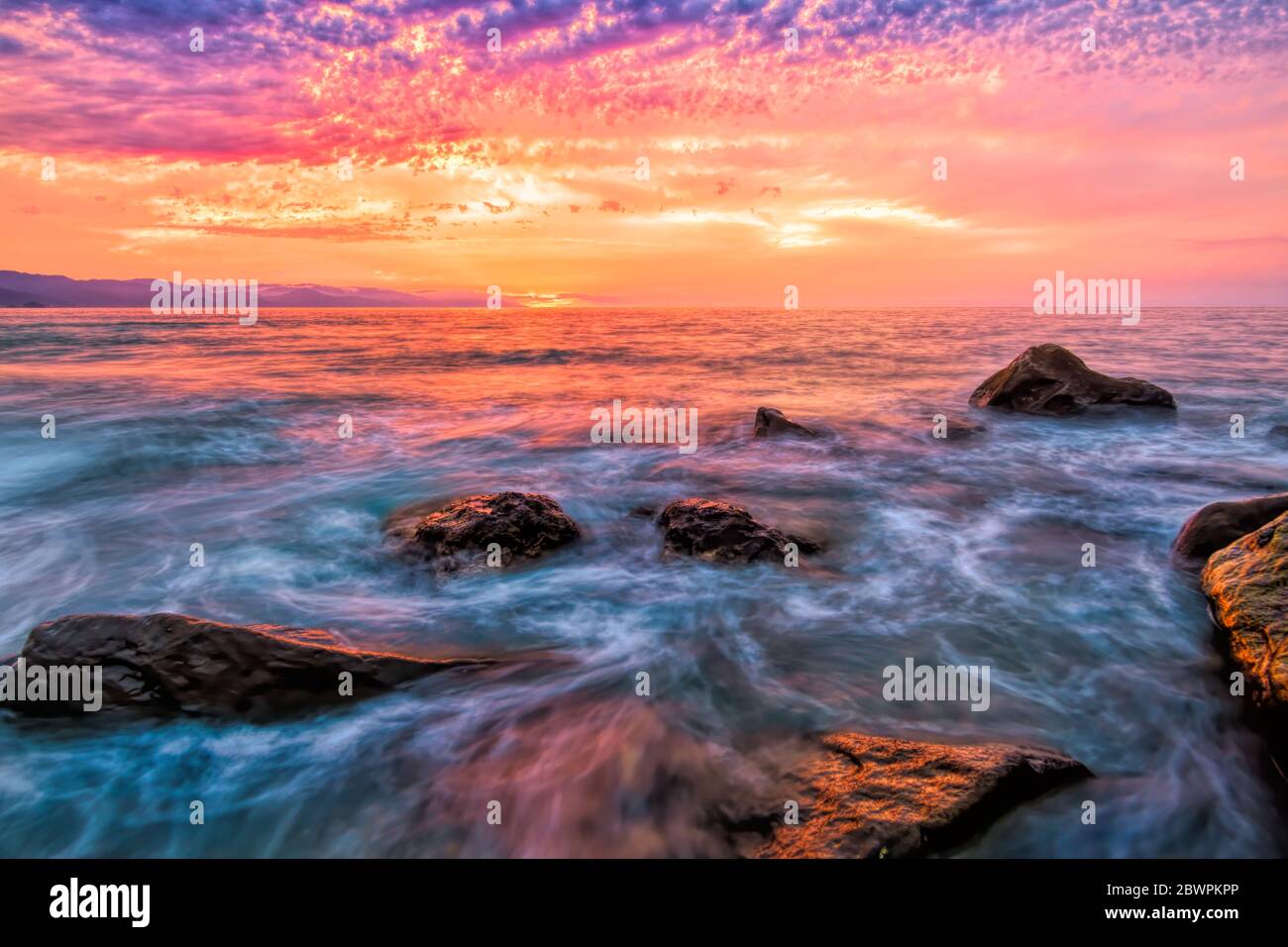 A Colorful Ocean Sunset Landscape as a Wave Comes to the Beach Shore ...