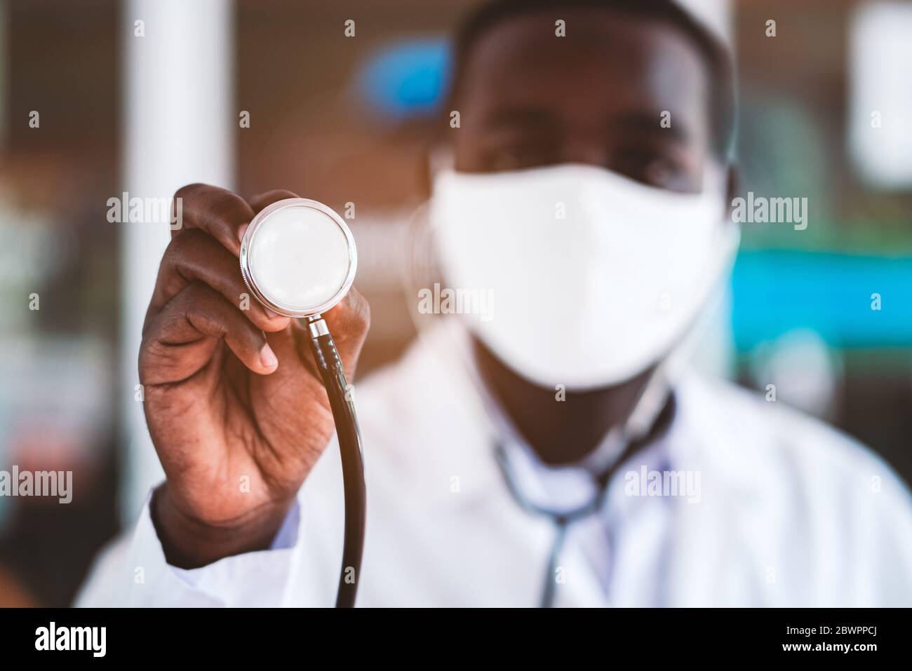 African doctor wear face mask and holding stethoscope with kind and ...