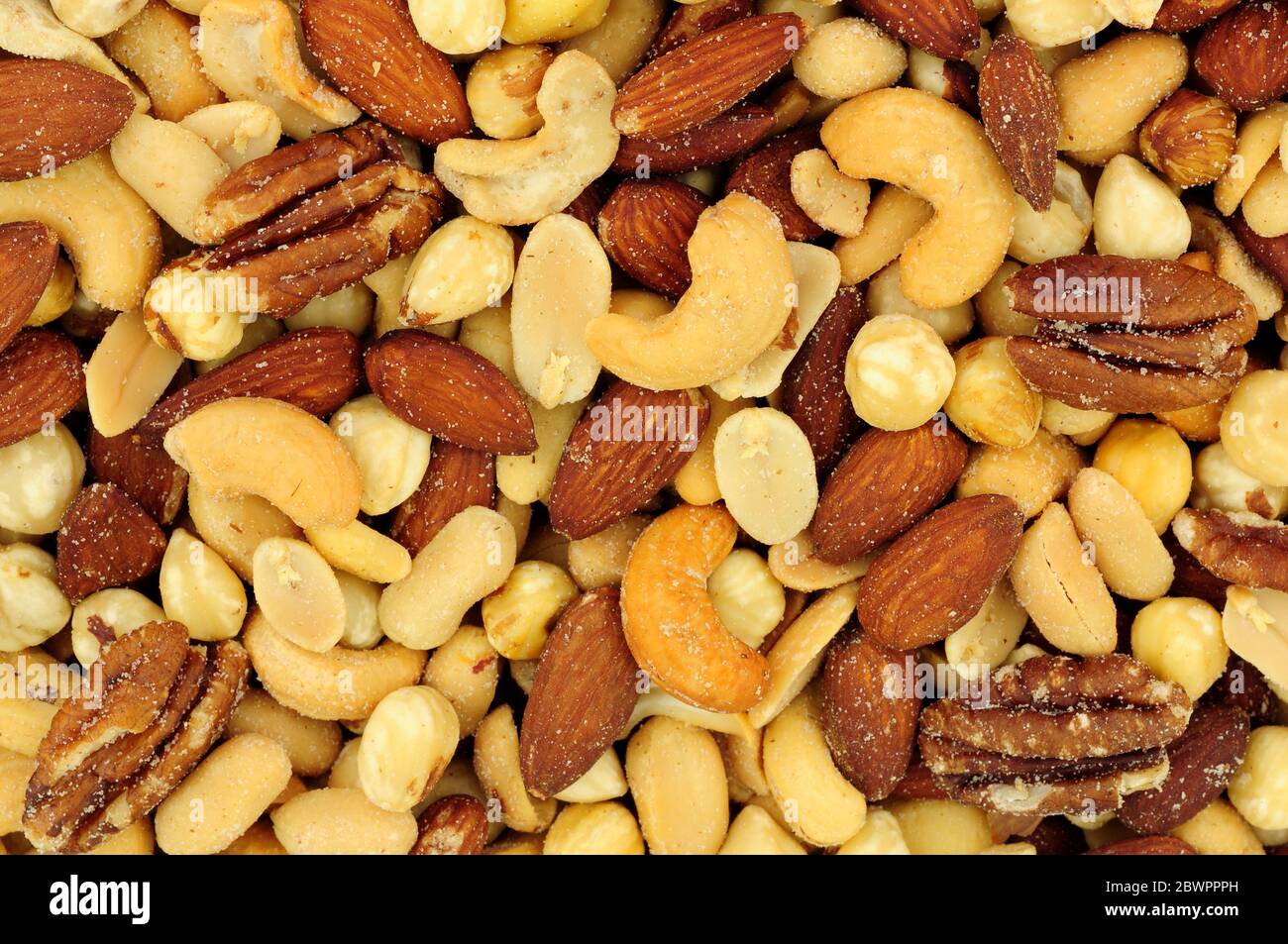 Roasted salted mixed nuts flavourful snacking background Stock Photo ...