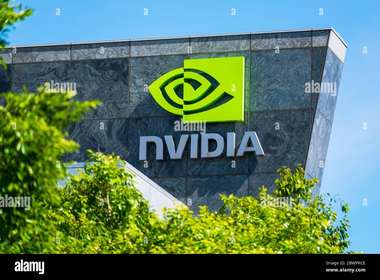 Nvidia logo and sign on headquarters. Blurred foreground with green ...