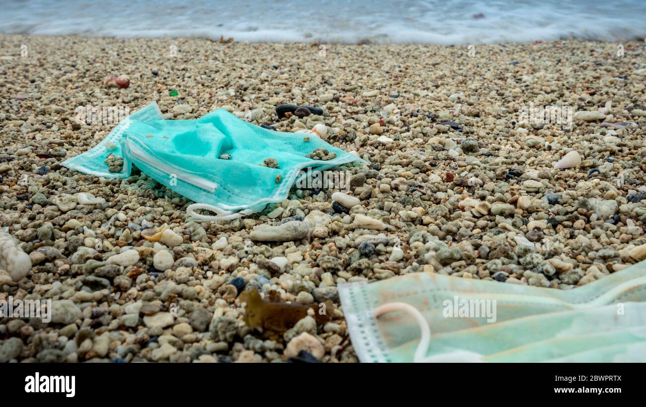 Waste during COVID-19. Discarded to ocean coronavirus single-use face ...