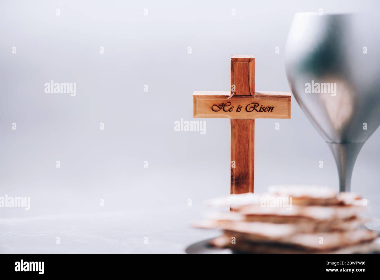 Matzos unleavened bread, chalice of wine, wooden cross on grey ...