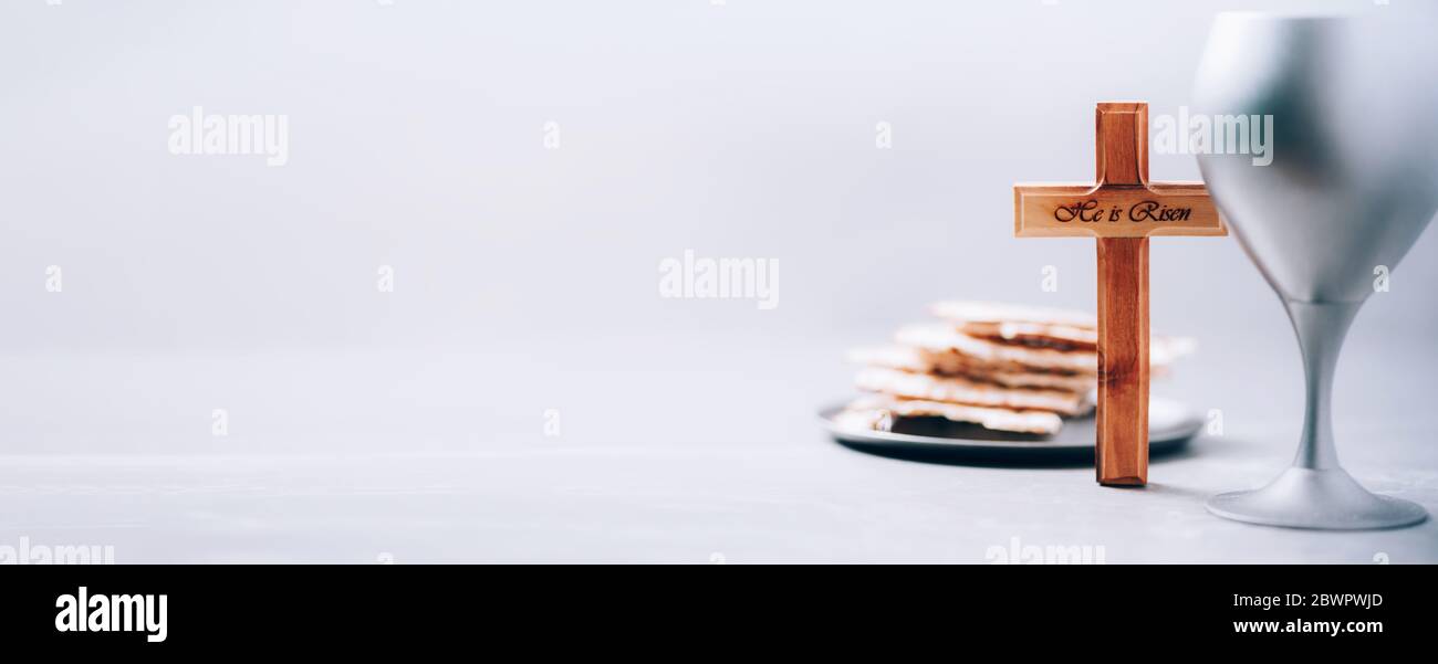 Matzos unleavened bread, chalice of wine, wooden cross on grey ...