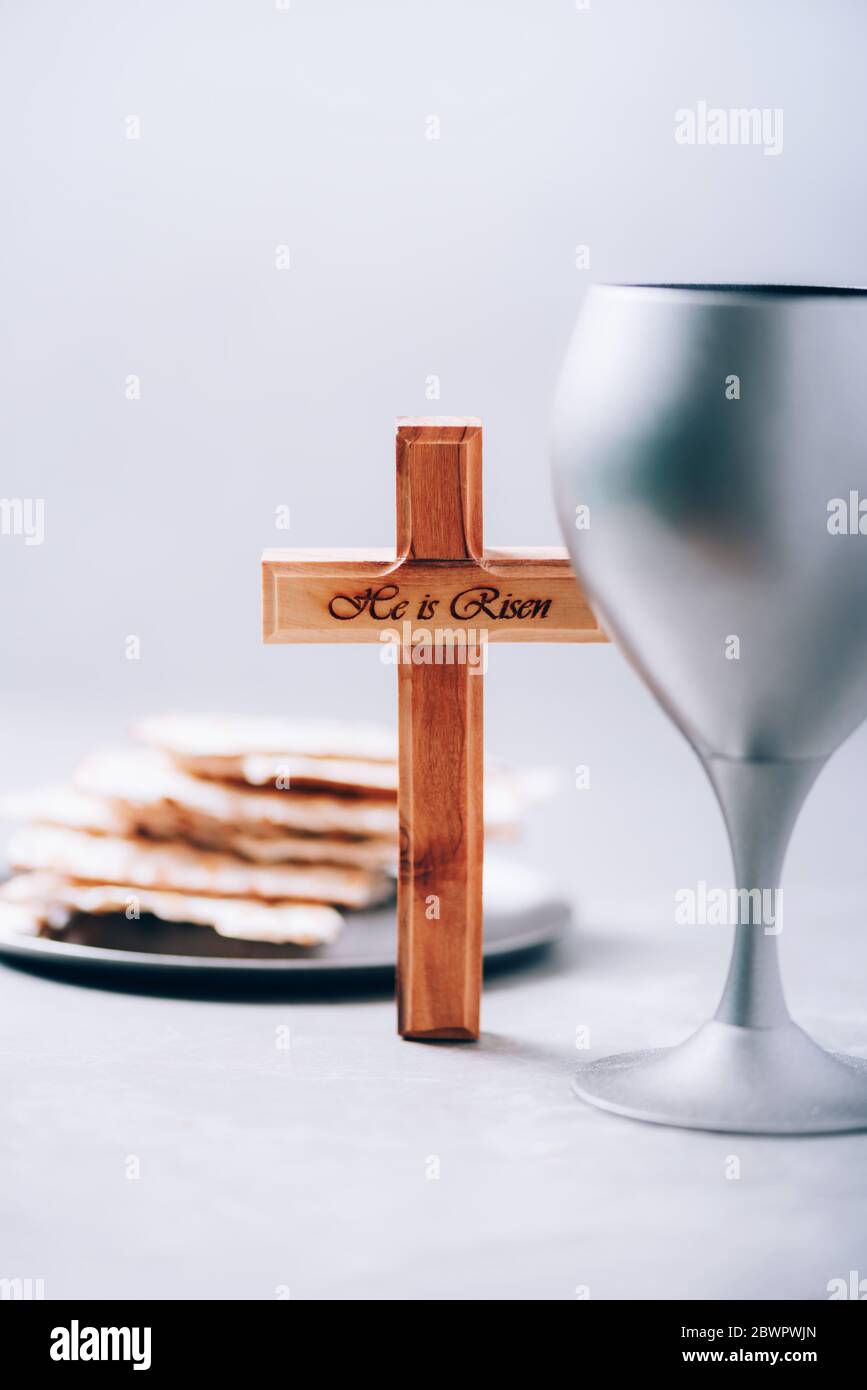 Matzos unleavened bread, chalice of wine, wooden cross on grey ...