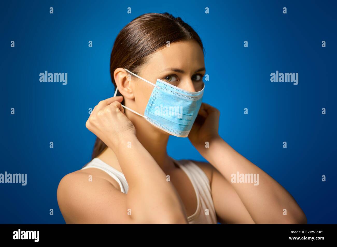 woman in white shirt shows how to wear a mask during a pandemic Stock ...