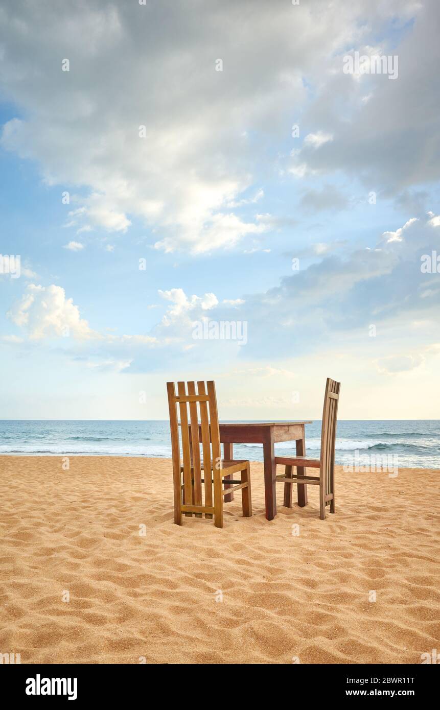 Wooden table and two chairs on a beach Stock Photo - Alamy