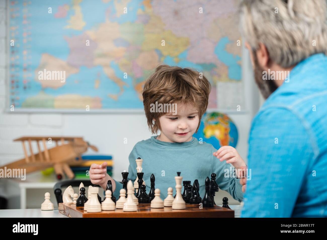 Concentrated boy developing chess strategy, playing board game. Child ...