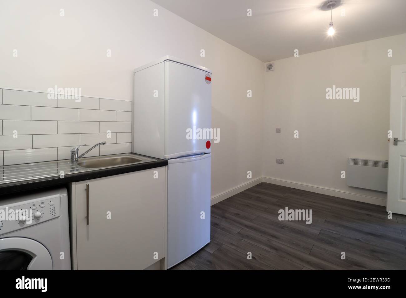 A modern British apartment kitchen and dining room with a grey wooden ...