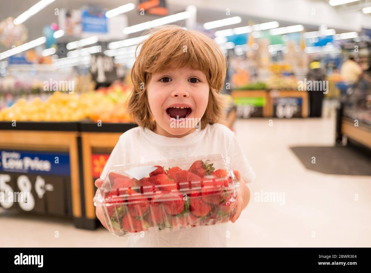 Cute toddler boy in a food store or a supermarket choosing fresh ...