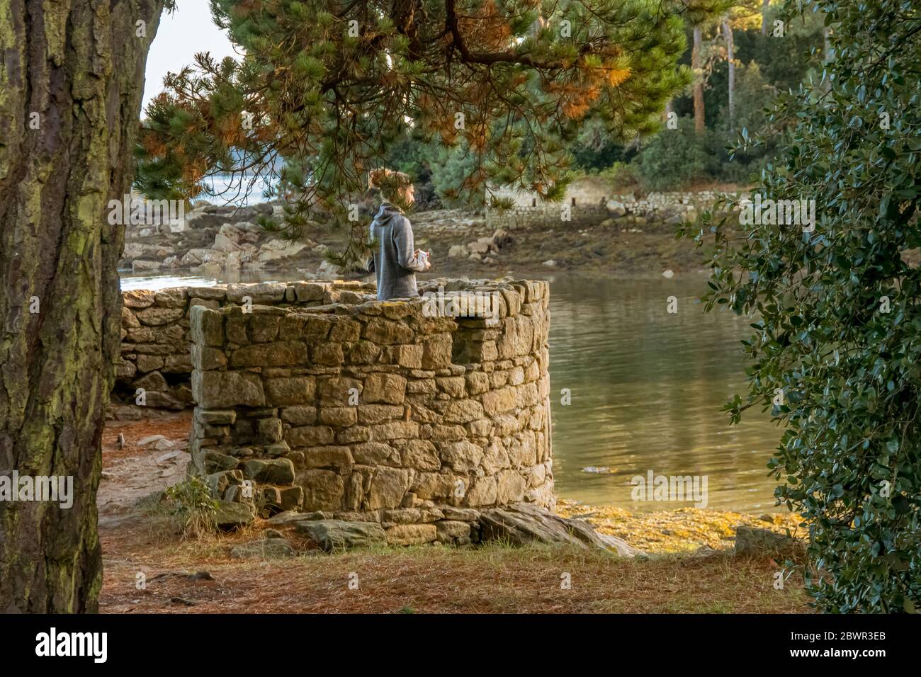 Man in stone tower on Bender Island in the Gulf of Morbihan. France ...