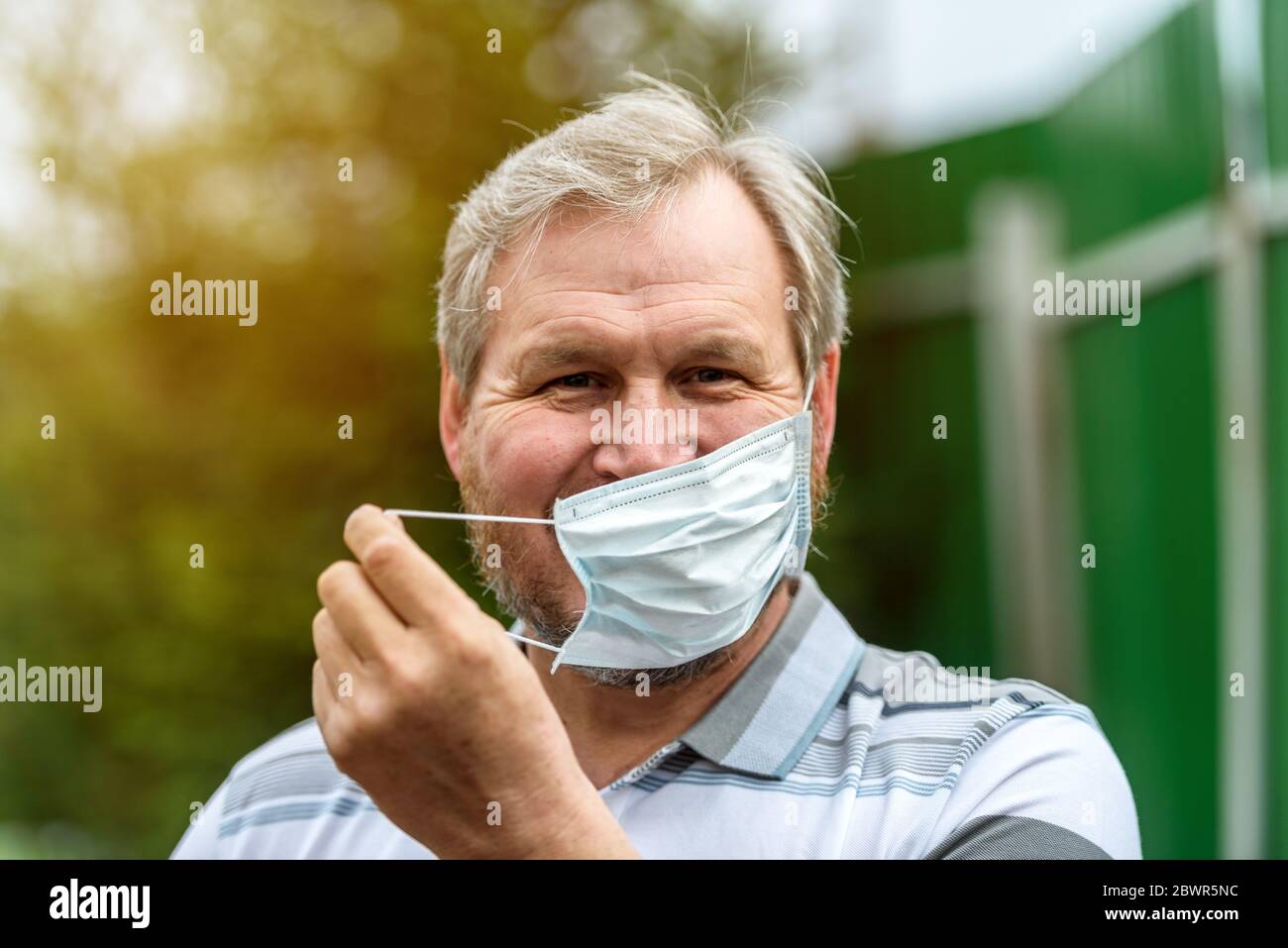 The man joyfully removes the medical mask from his face. End of the ...