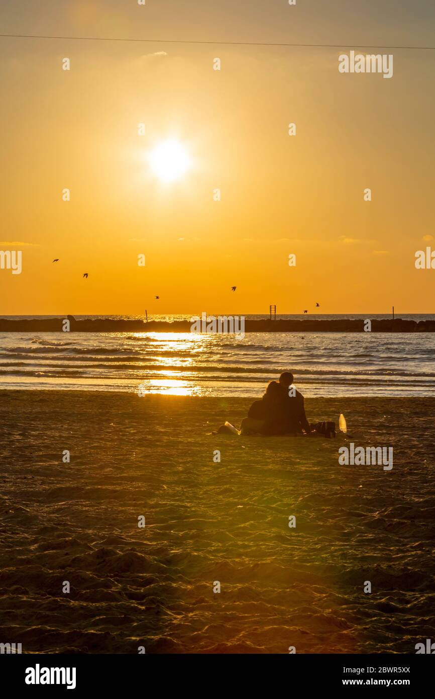 View of couple watching sunset on Frishman Beach, Hayarkon Street, Tel ...