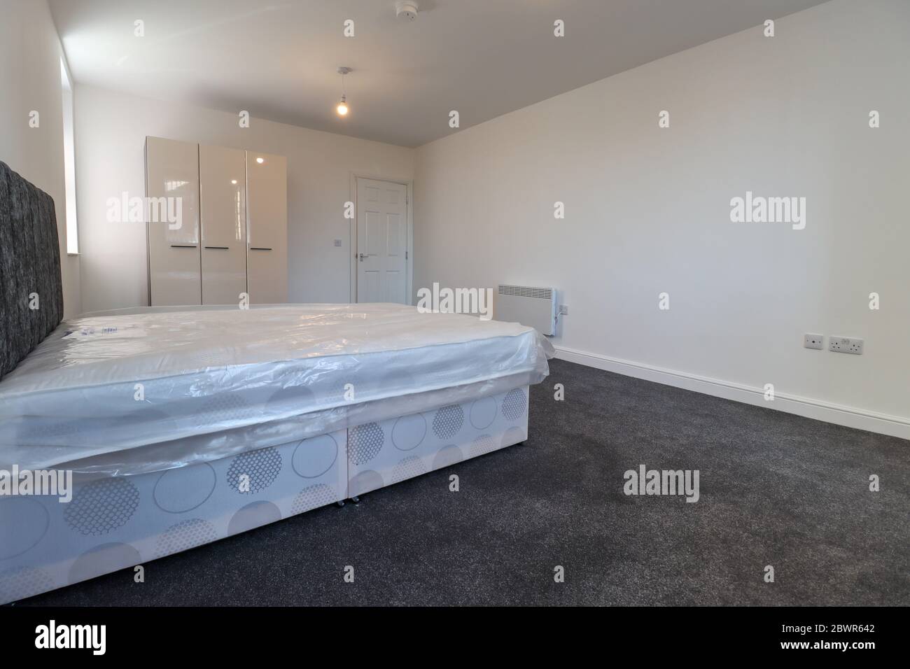 A newly decorated typical British UK bedroom with a large bed, with ...