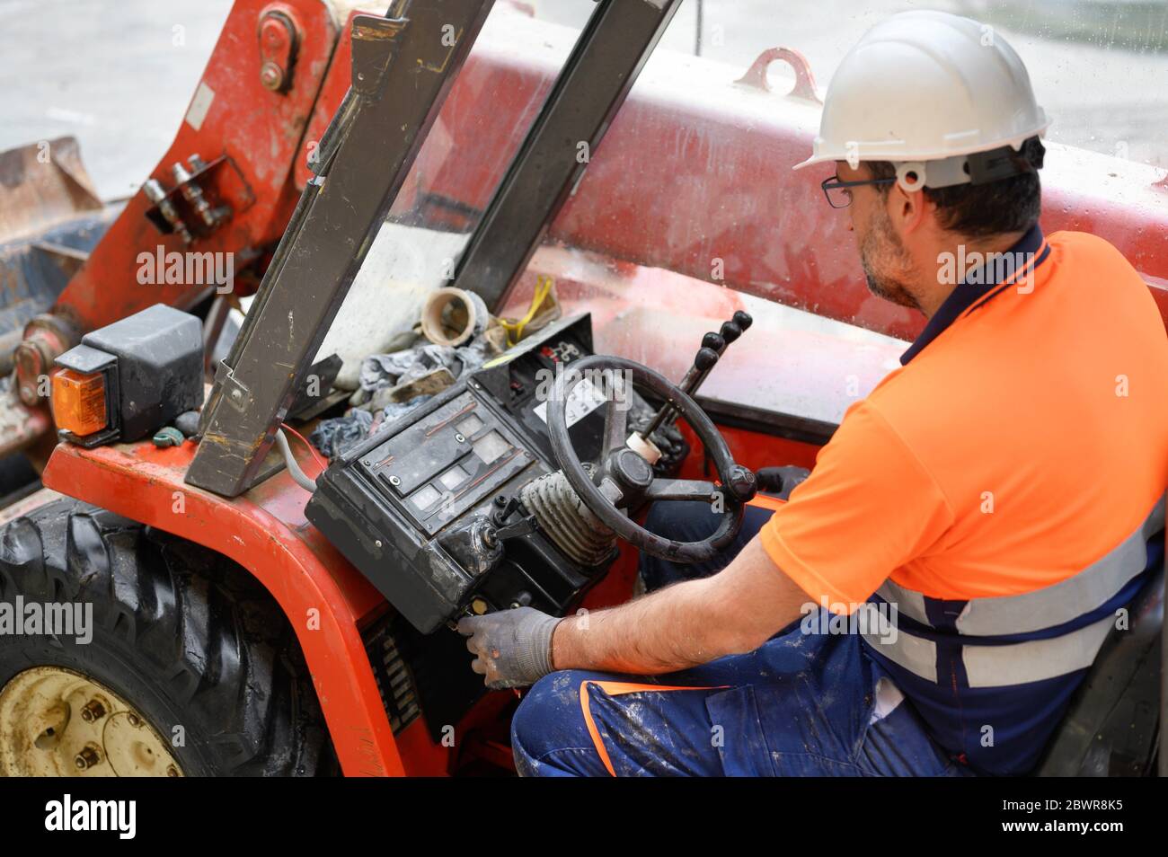 Construction worker starting the excavator machine Stock Photo - Alamy