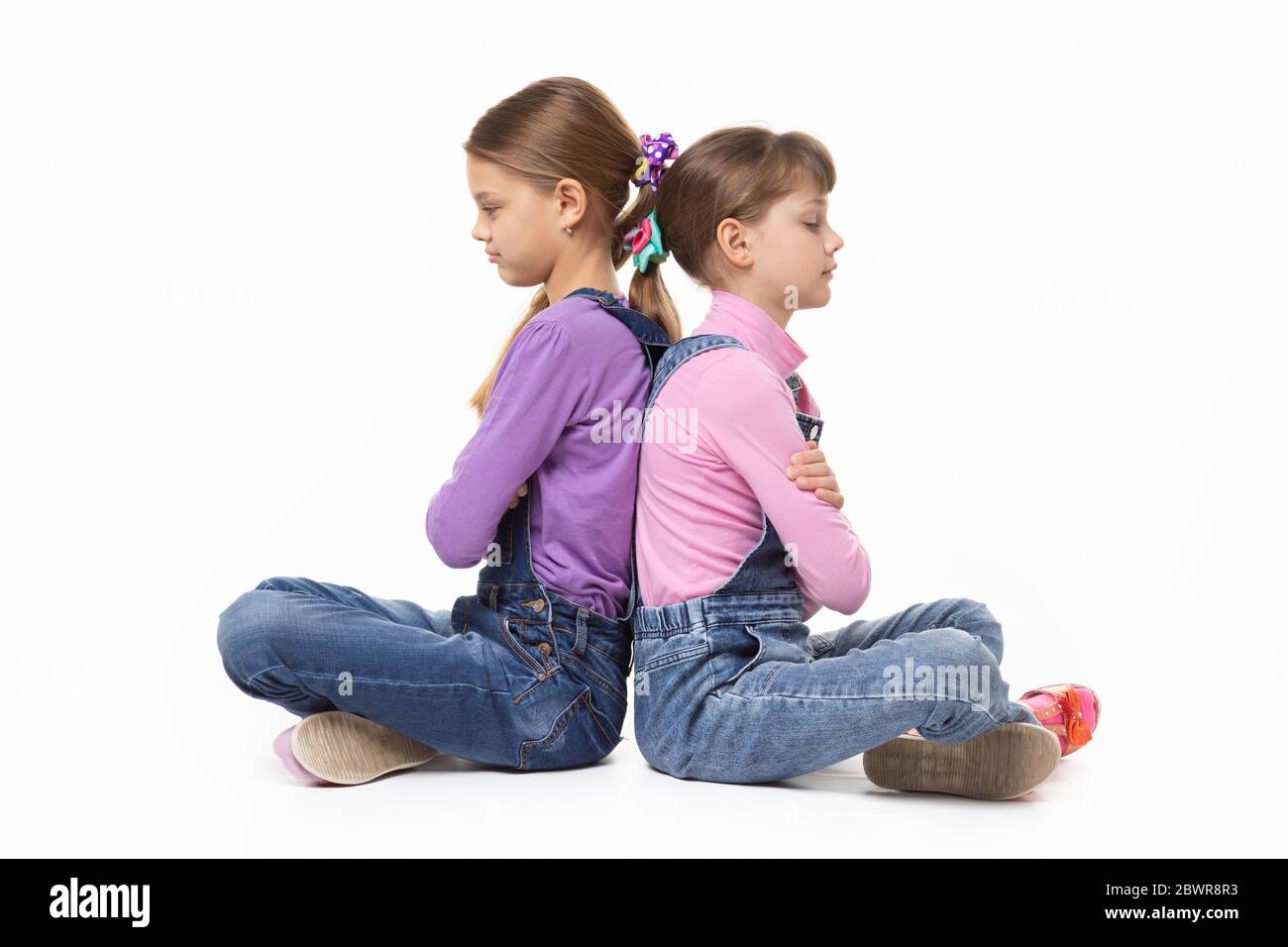 Two girls sitting back to back on Cut Out Stock Images & Pictures - Alamy