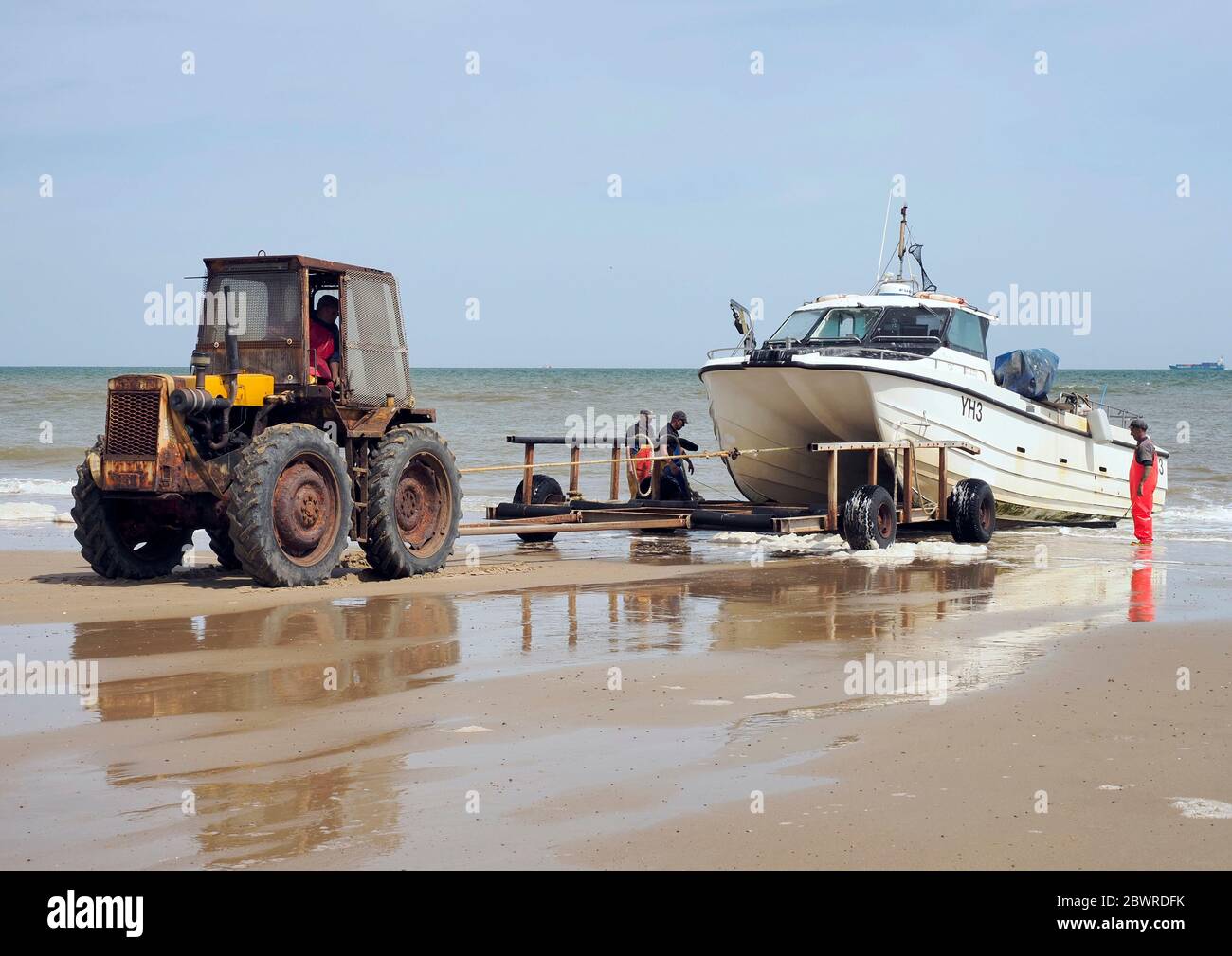 A modern catamaran style crab boat is dragged up the beach at Cromer ...