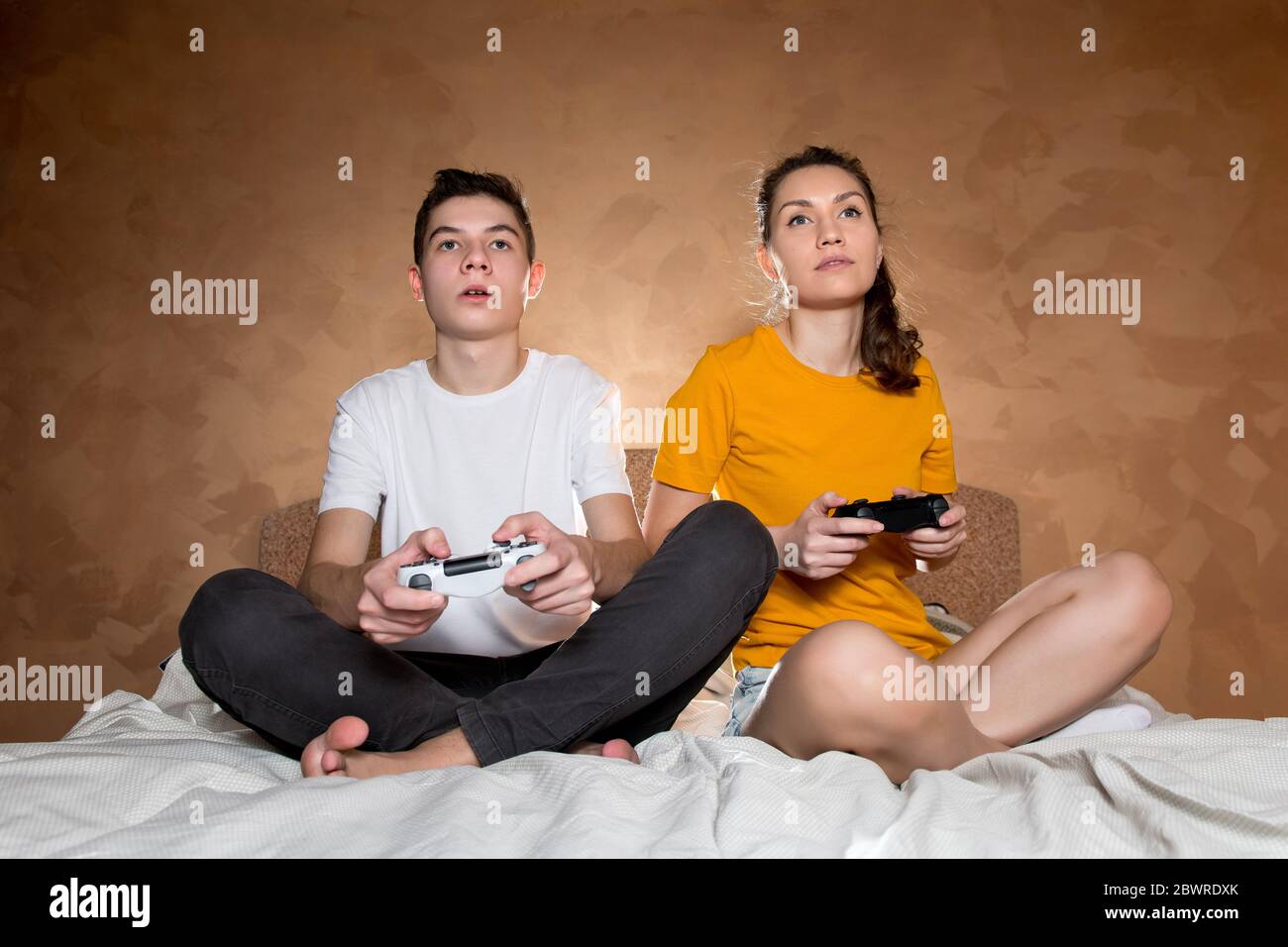 Brother and sister enthusiastically calmly play a video game using ...