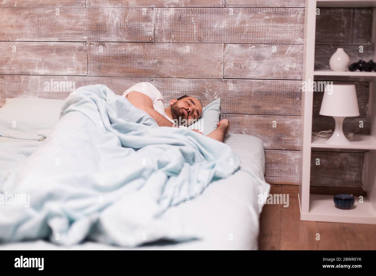 Tired man sleeping on comfortable bed having a good dream Stock Photo ...