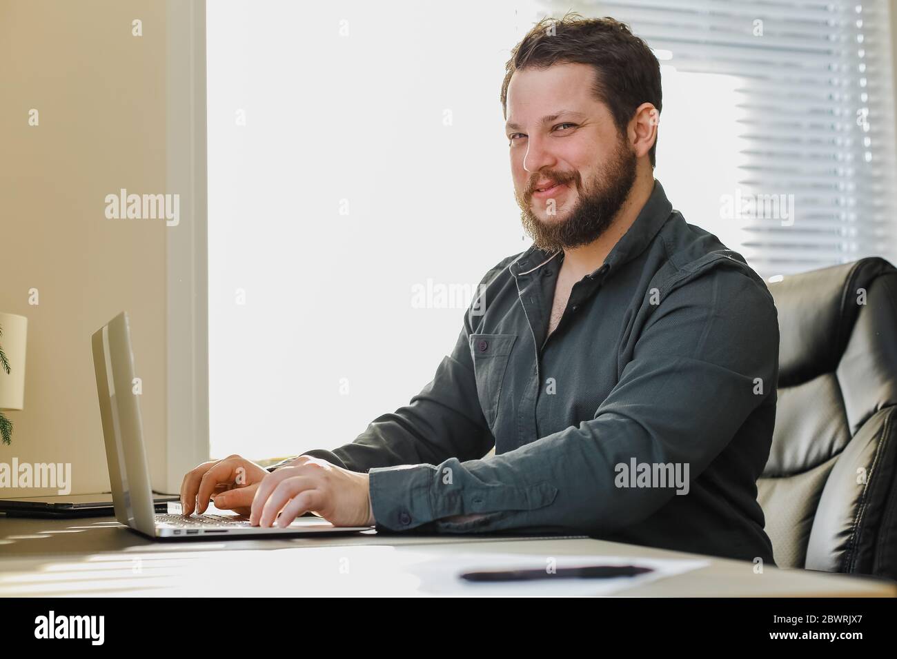 Male manager sitting at office desk working on laptop computer Stock ...
