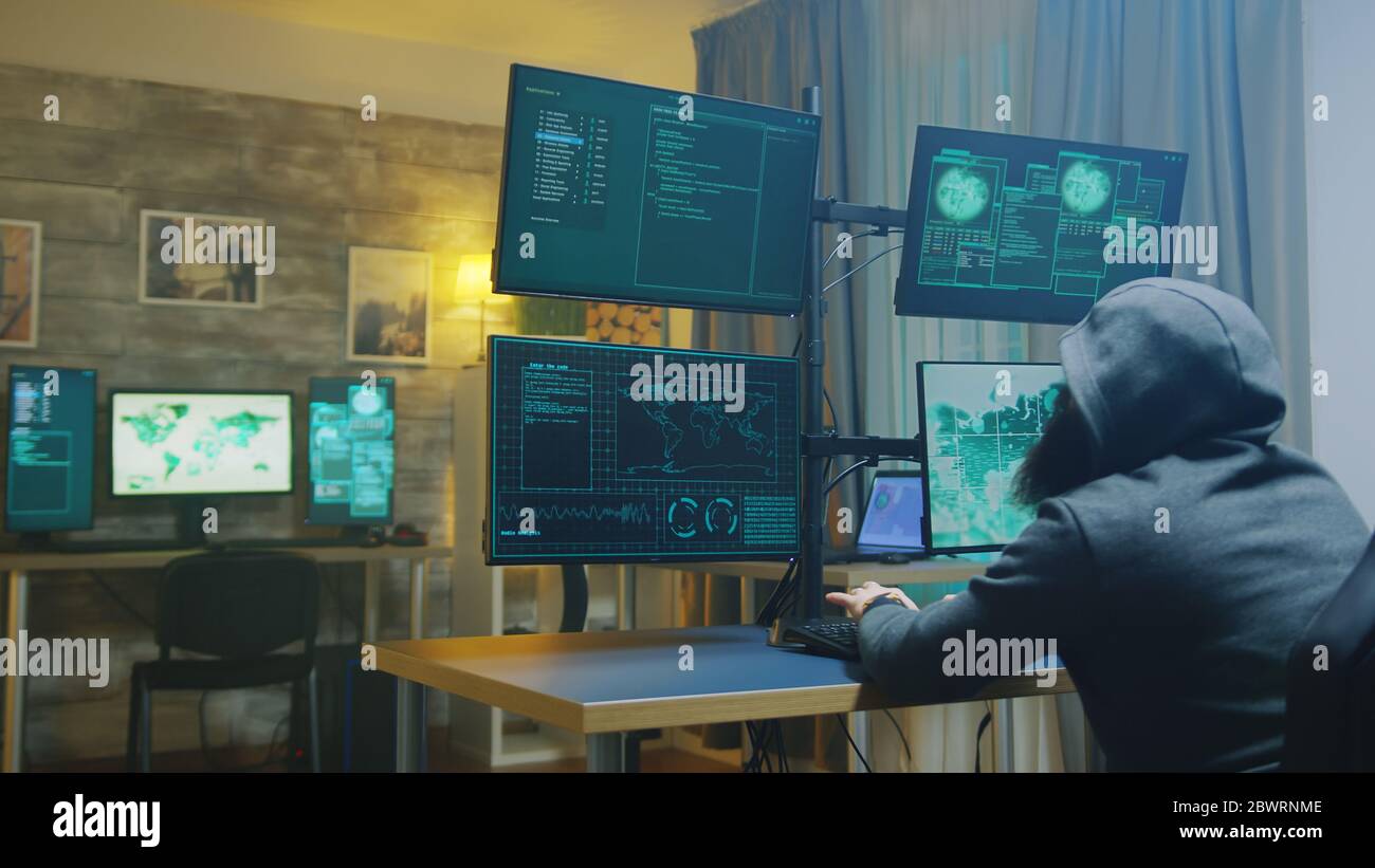Bearded cyber criminal wearing a hoodie while hacking government ...